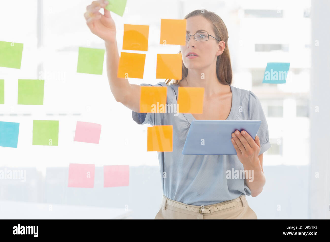 Concentrated artist looking at colorful sticky notes Stock Photo - Alamy