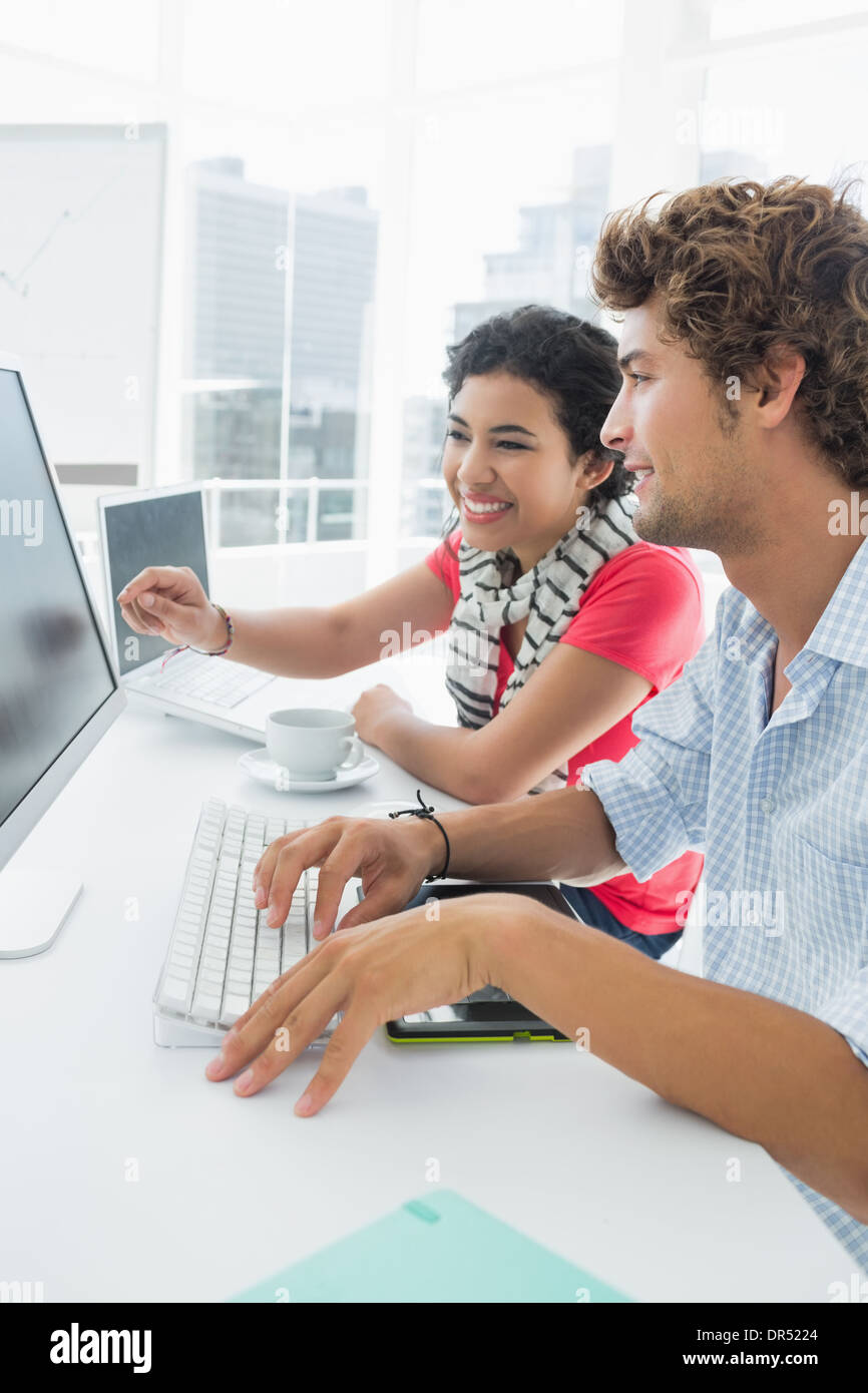 Casual couple using computer in office Stock Photo - Alamy