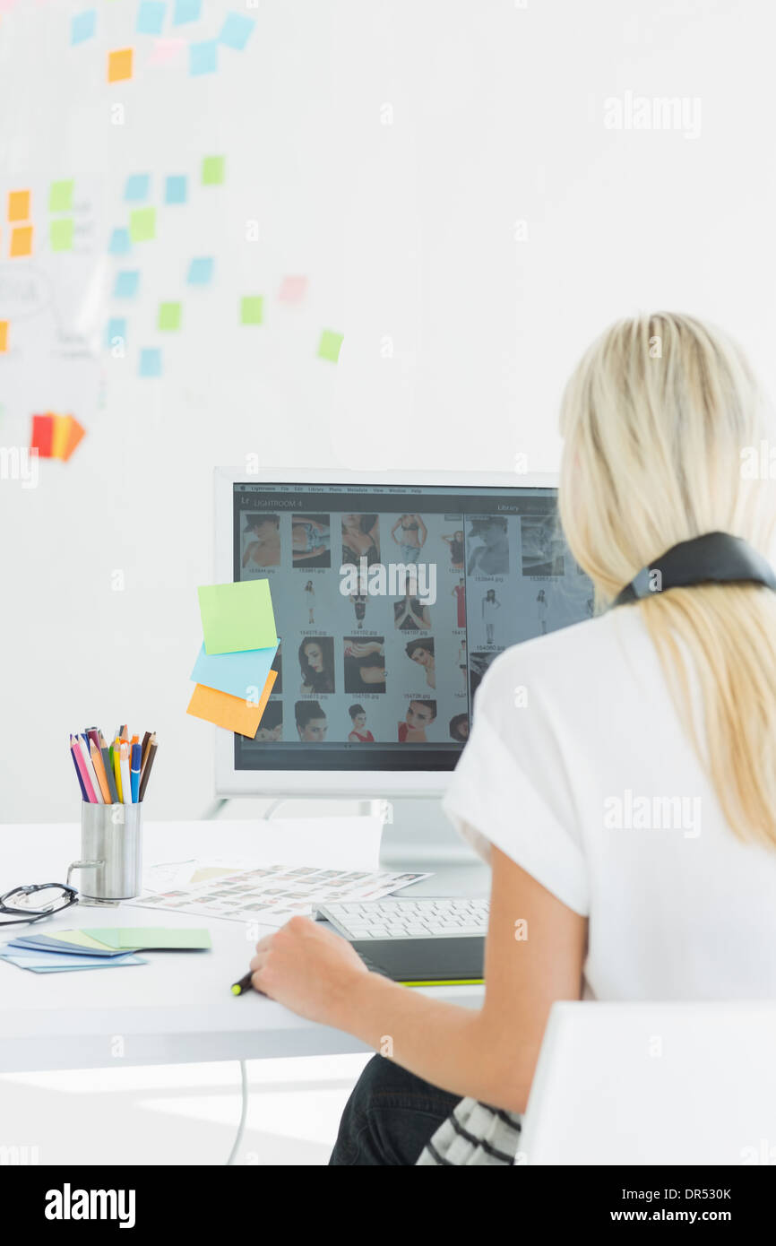 Rear view of a woman using computer in office Stock Photo - Alamy