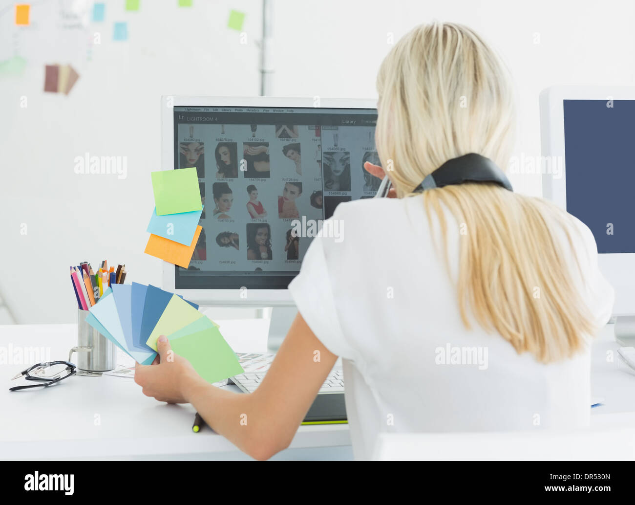 Rear view of a casual woman using computer in office Stock Photo - Alamy