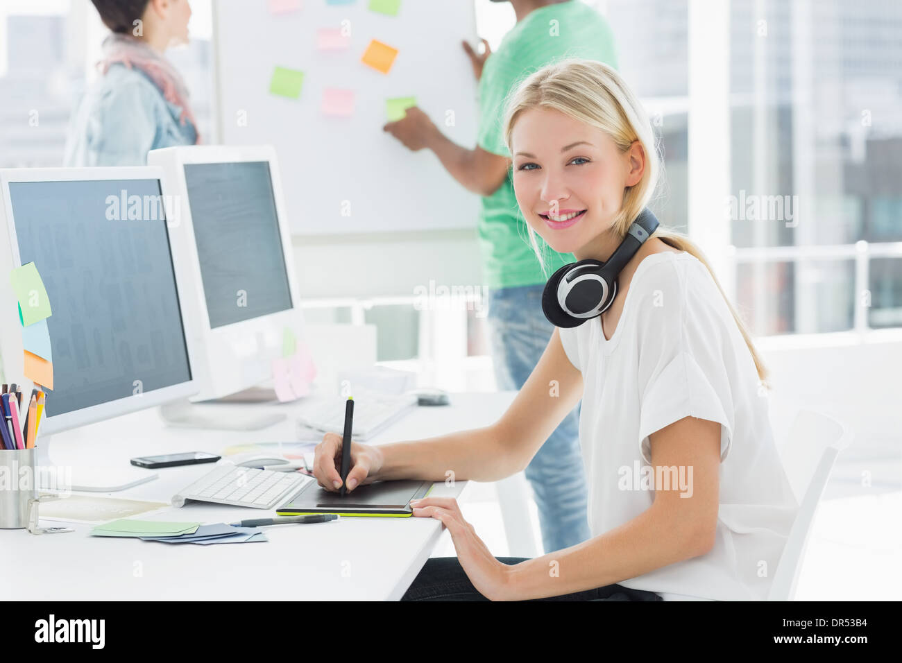 Artist drawing something on graphic tablet with colleagues behind Stock ...