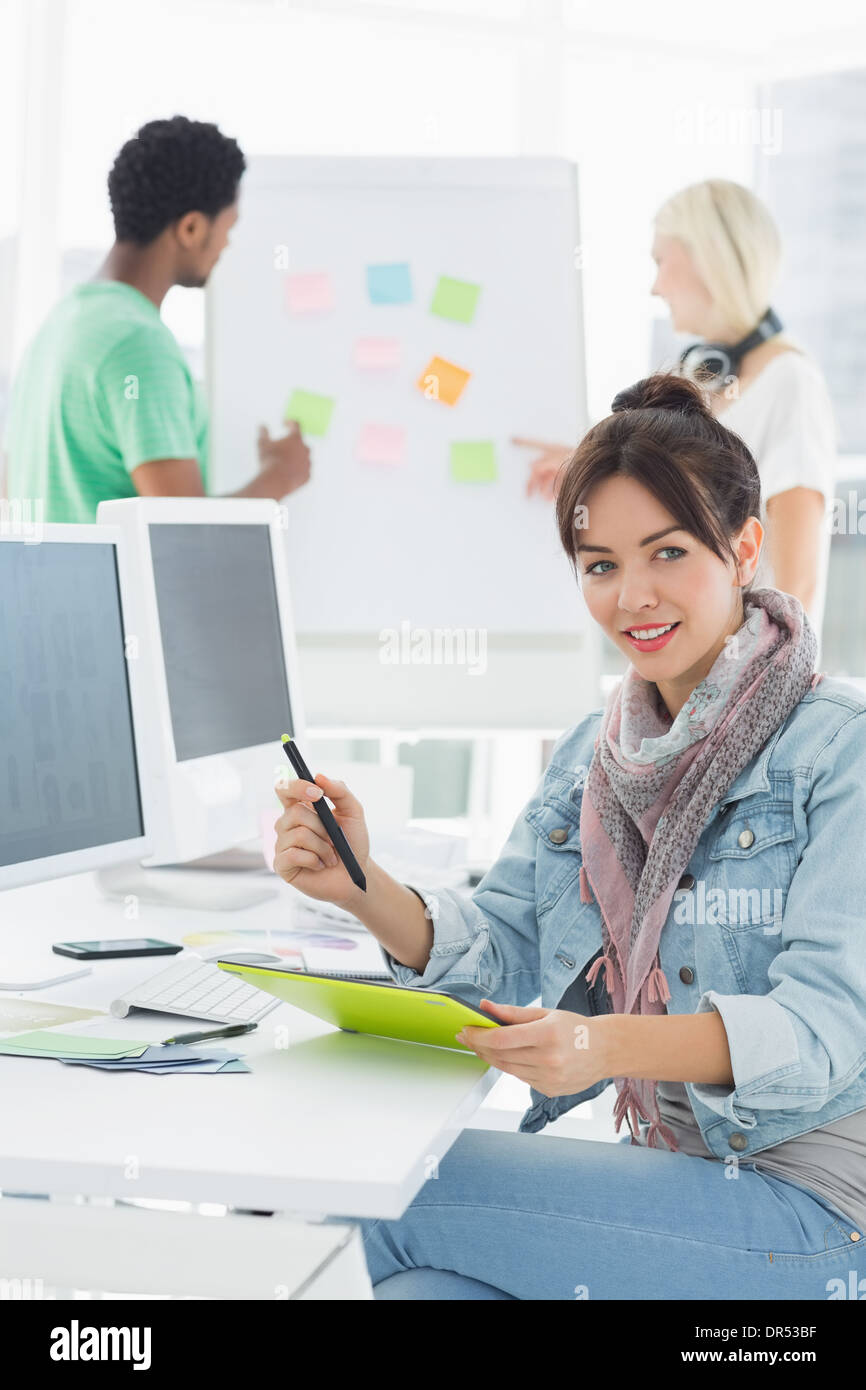 Artist drawing something on graphic tablet with colleagues behind Stock ...