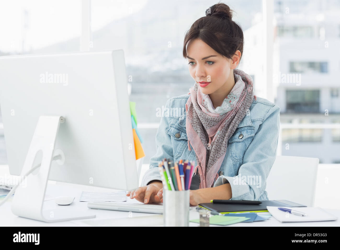 Casual woman using computer in office Stock Photo - Alamy