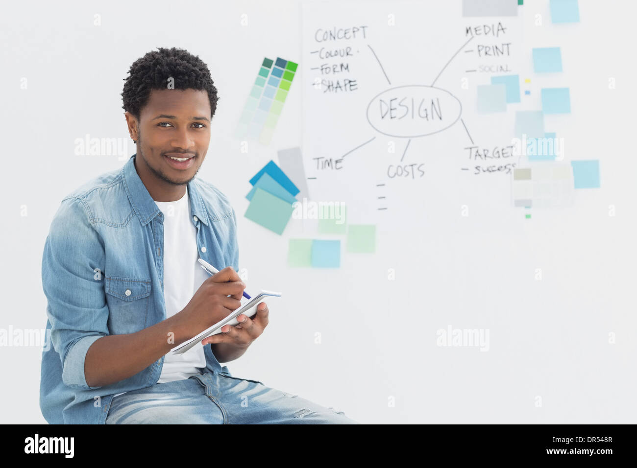 Smiling male artist writing notes in front of whiteboard Stock Photo ...
