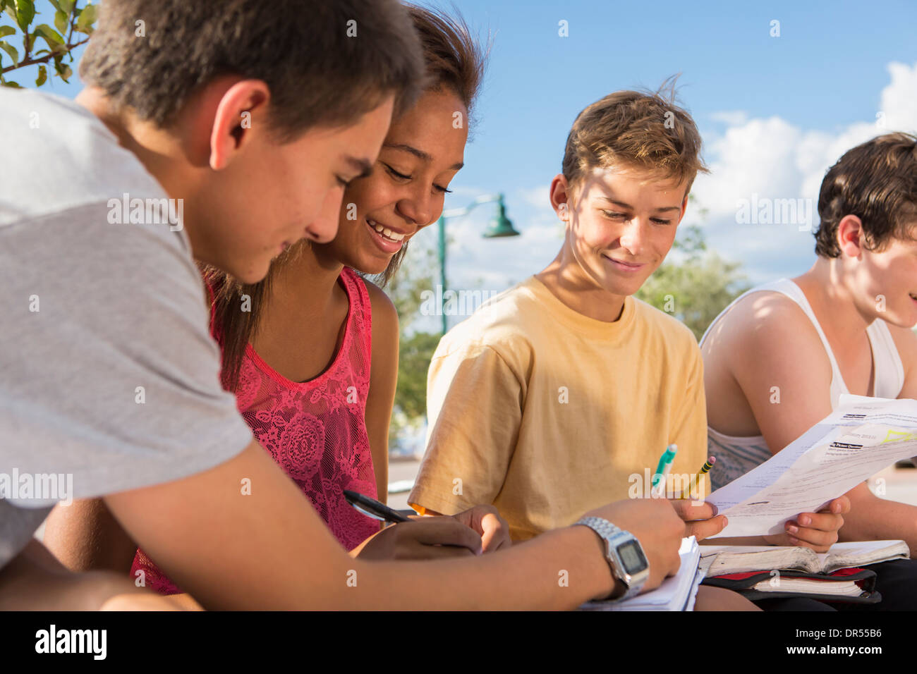 Teenagers doing homework together outdoors Stock Photo - Alamy