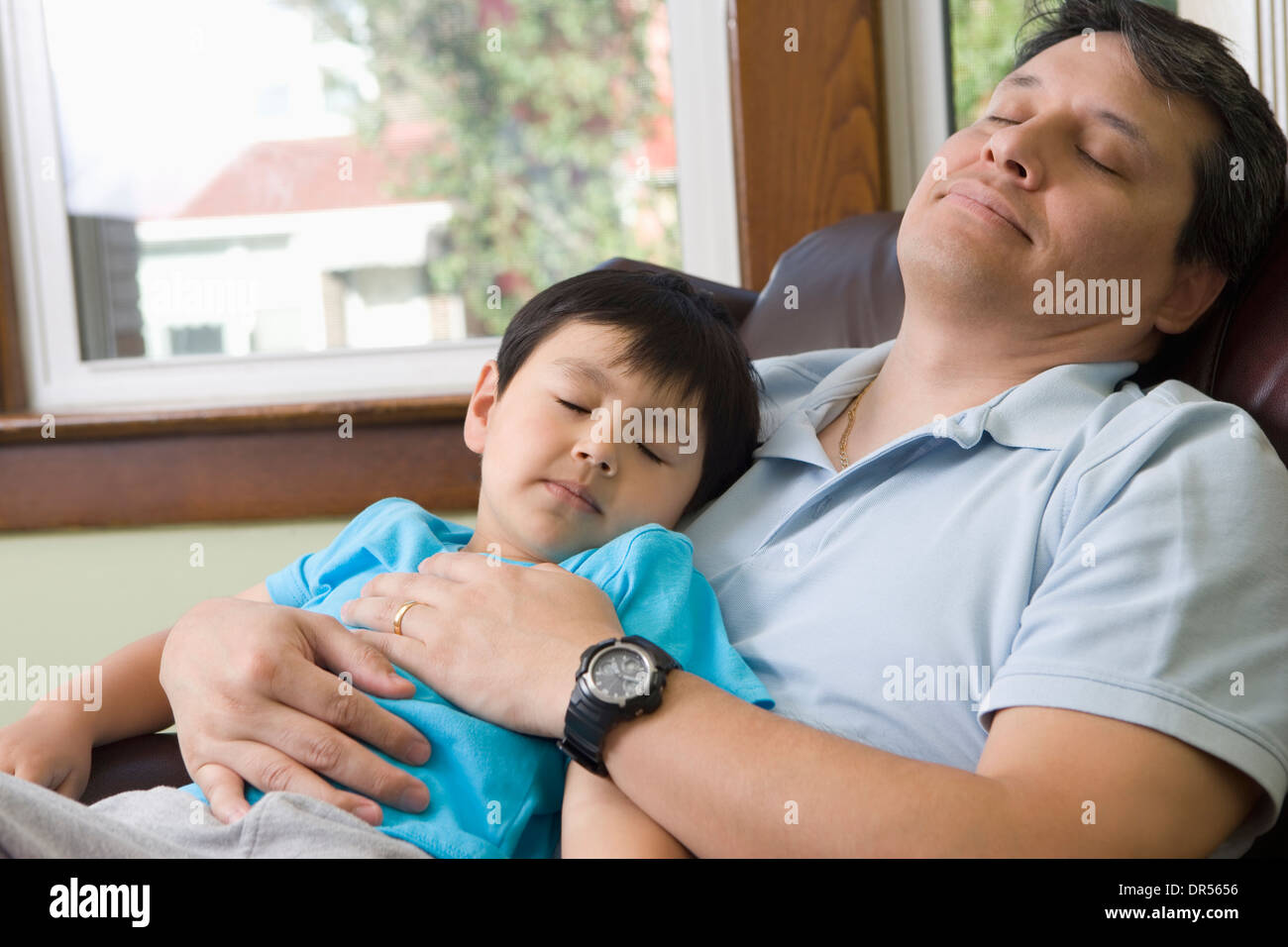 Hispanic father and son napping Stock Photo - Alamy