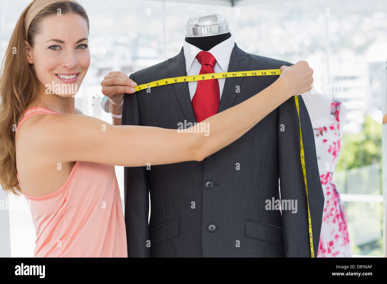 Female fashion designer measuring suit on dummy Stock Photo - Alamy