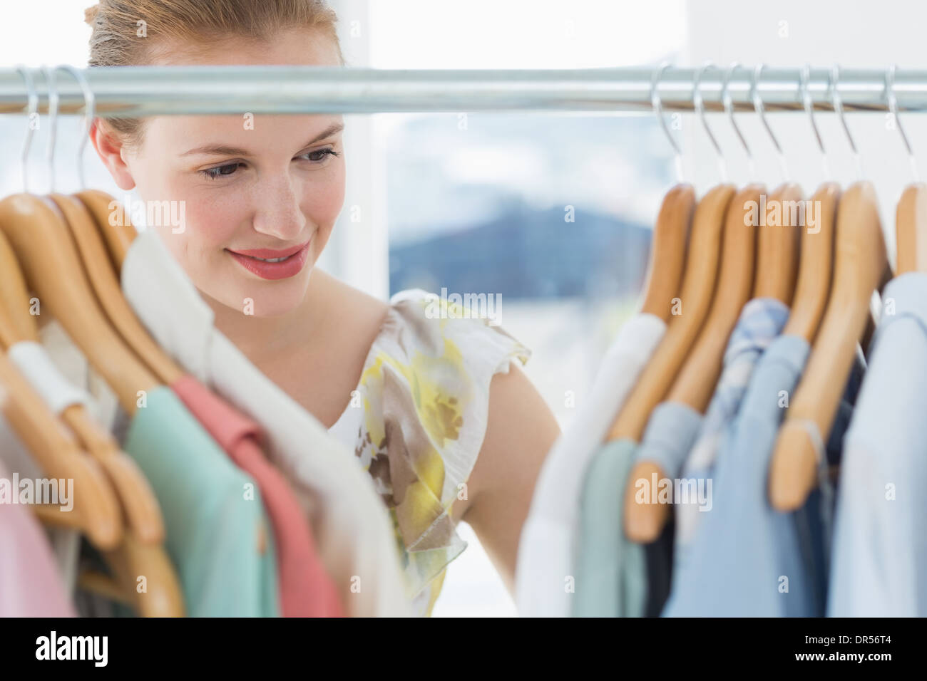 Female customer selecting clothes at store Stock Photo - Alamy