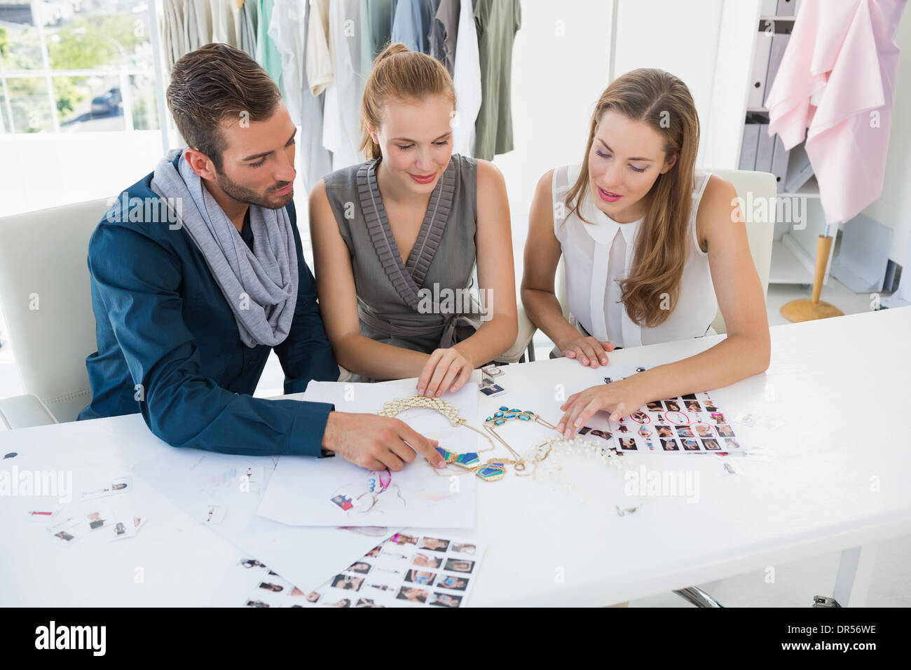 Three fashion designers discussing designs Stock Photo - Alamy