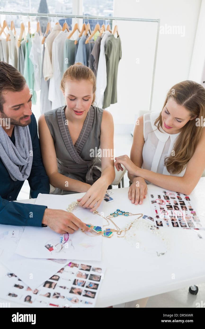 Three fashion designers discussing designs in a studio Stock Photo - Alamy