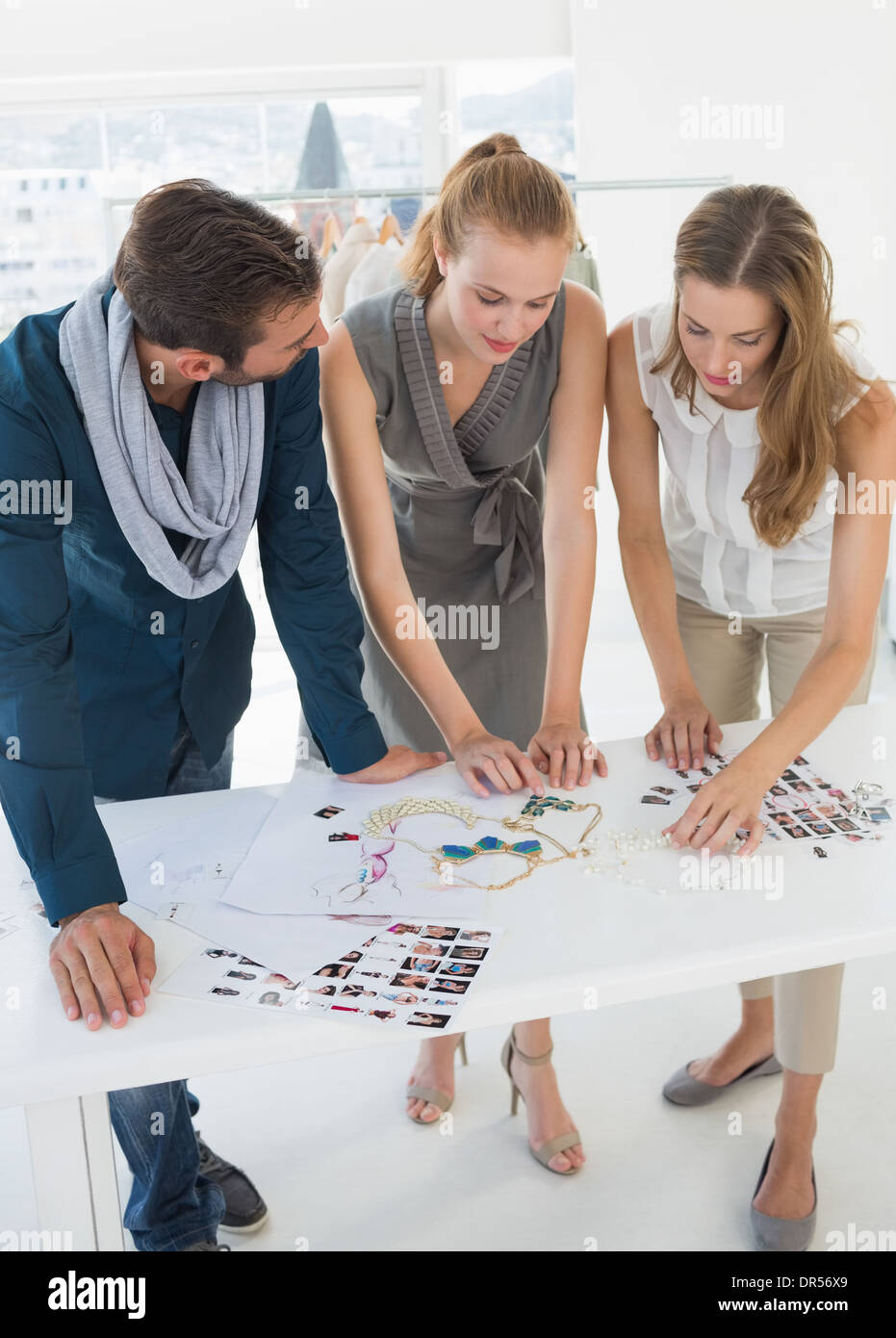 Three fashion designers discussing designs Stock Photo - Alamy
