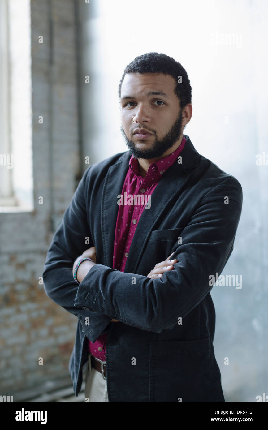 Mixed race businessman standing in warehouse Stock Photo - Alamy
