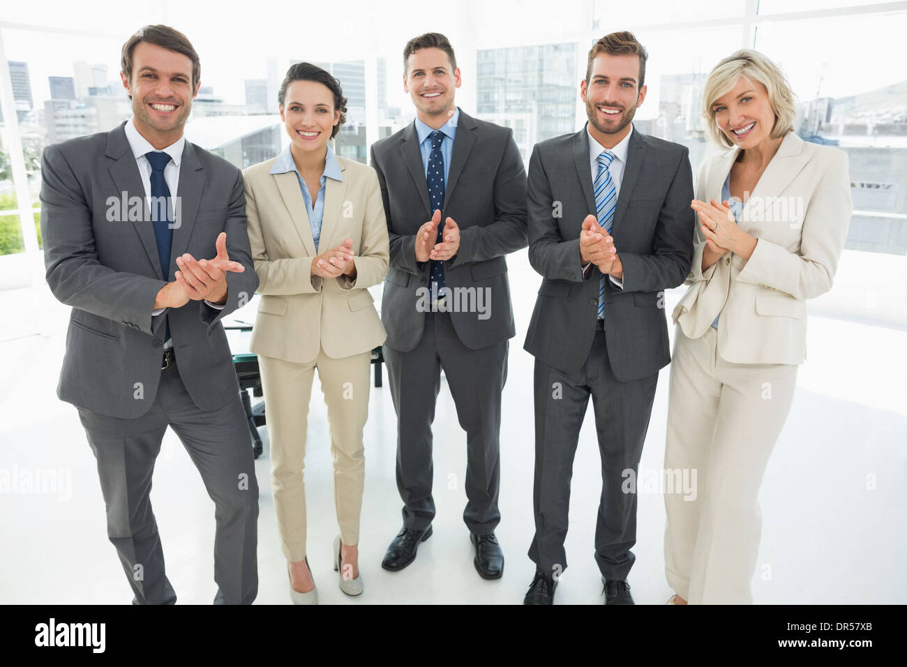 Business team clapping hands together in office Stock Photo - Alamy