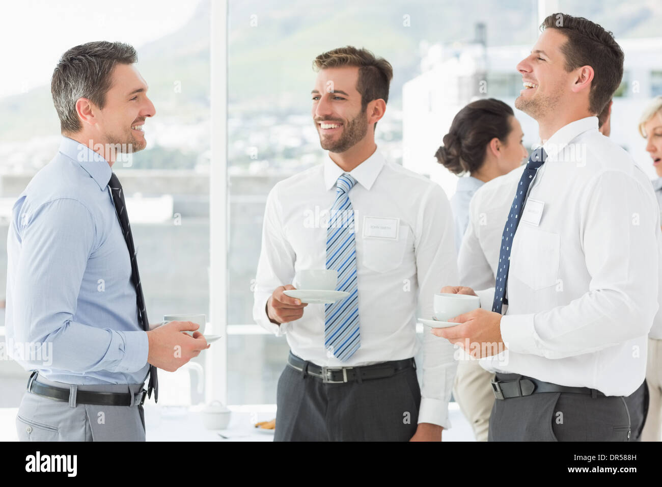Business colleagues in discussion with tea cups during break Stock ...