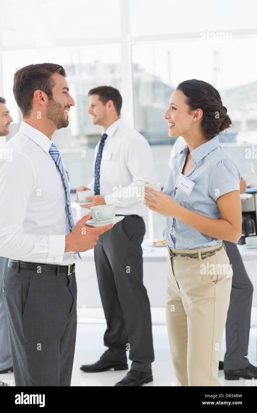 Colleagues in discussion with tea cups during break Stock Photo - Alamy