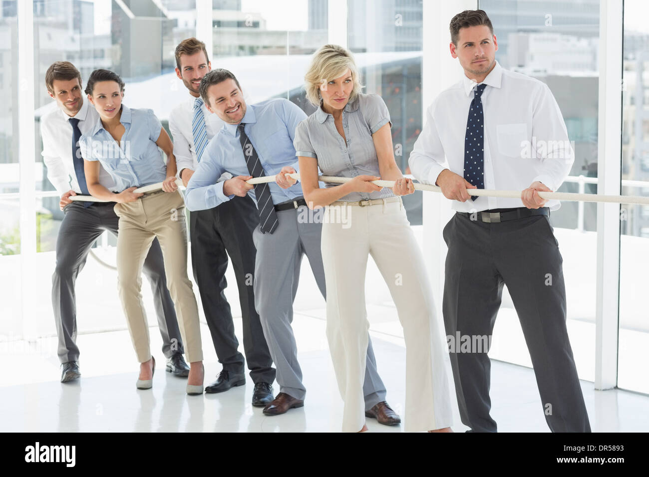 Group of business people pulling rope in office Stock Photo - Alamy