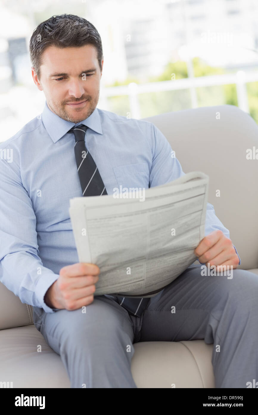 Well dressed young man reading newspaper at home Stock Photo - Alamy