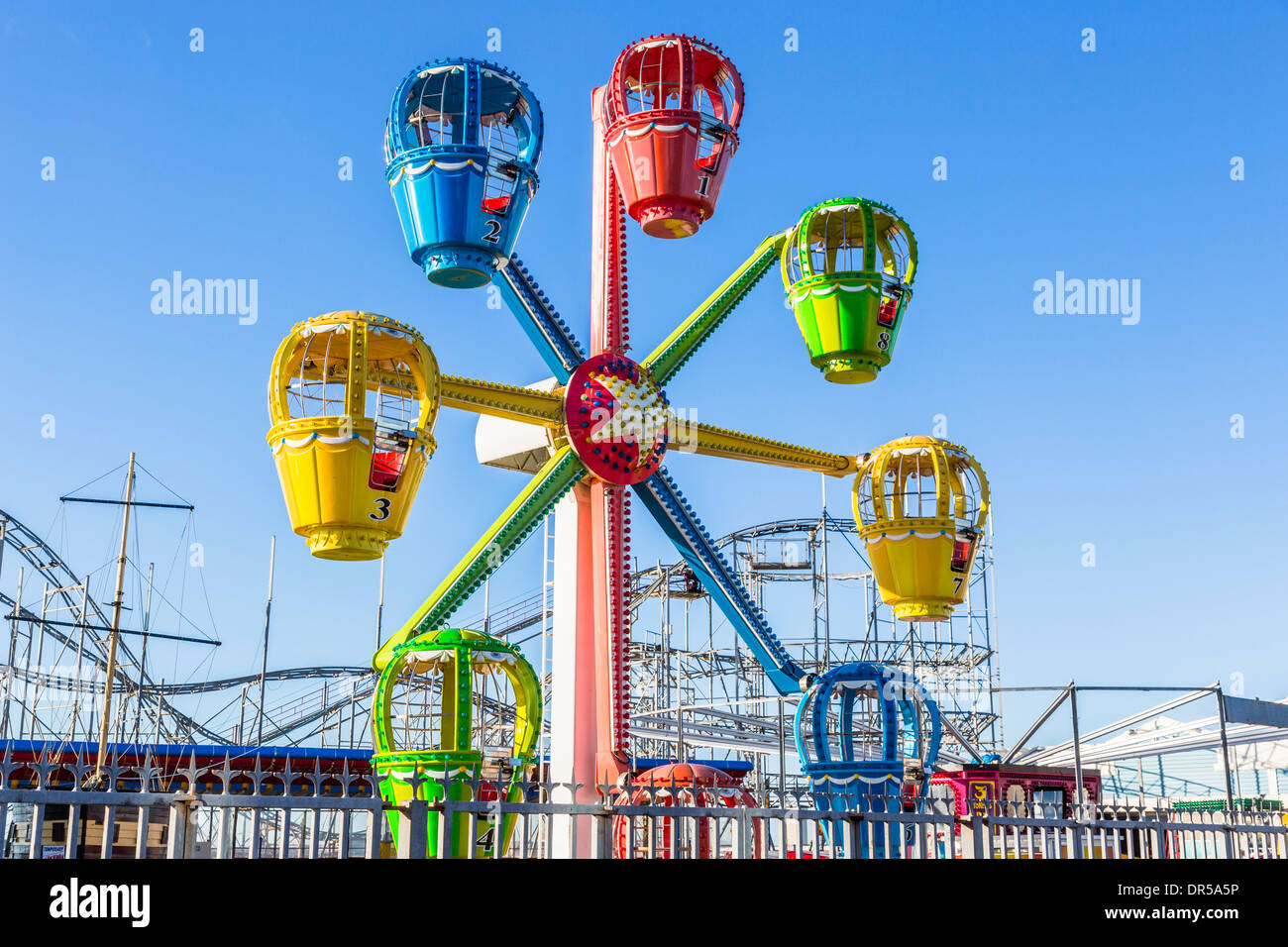 Brightly coloured ferris wheel ride at funfair on Clarence Pier ...