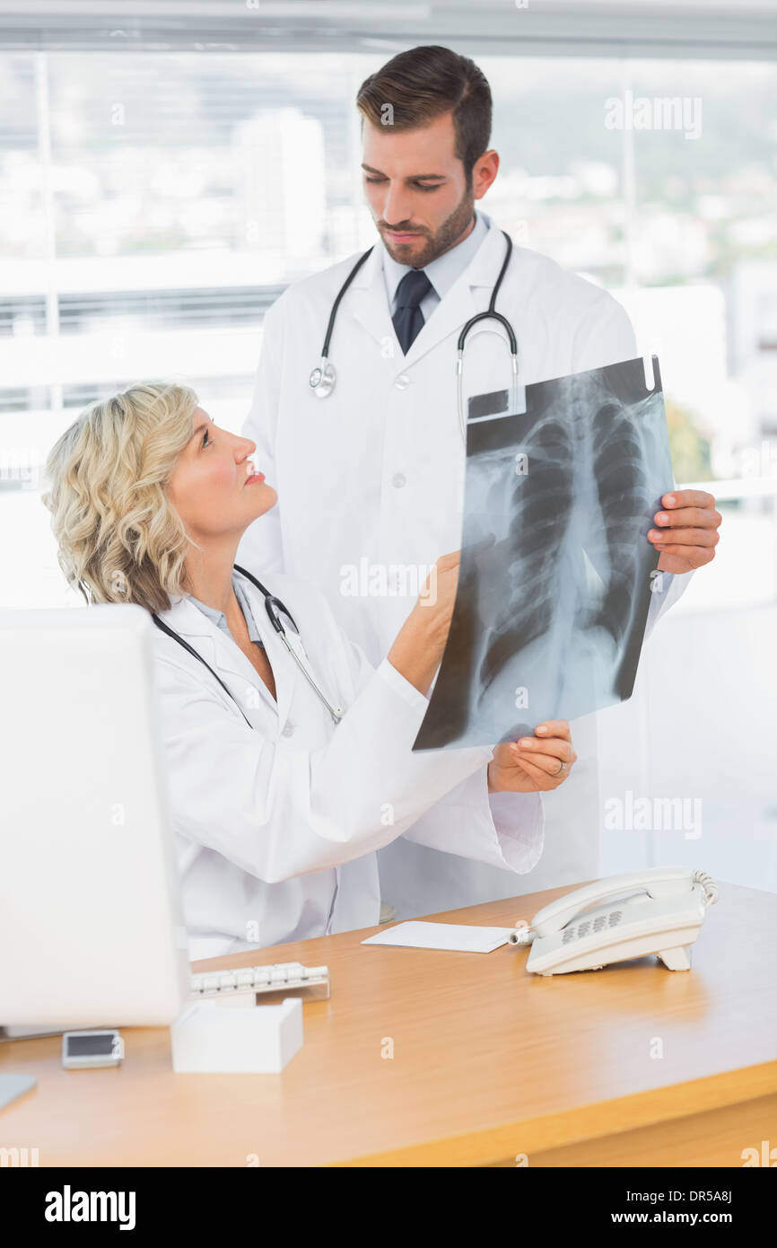 Doctor explaining x-ray to her male colleague Stock Photo - Alamy