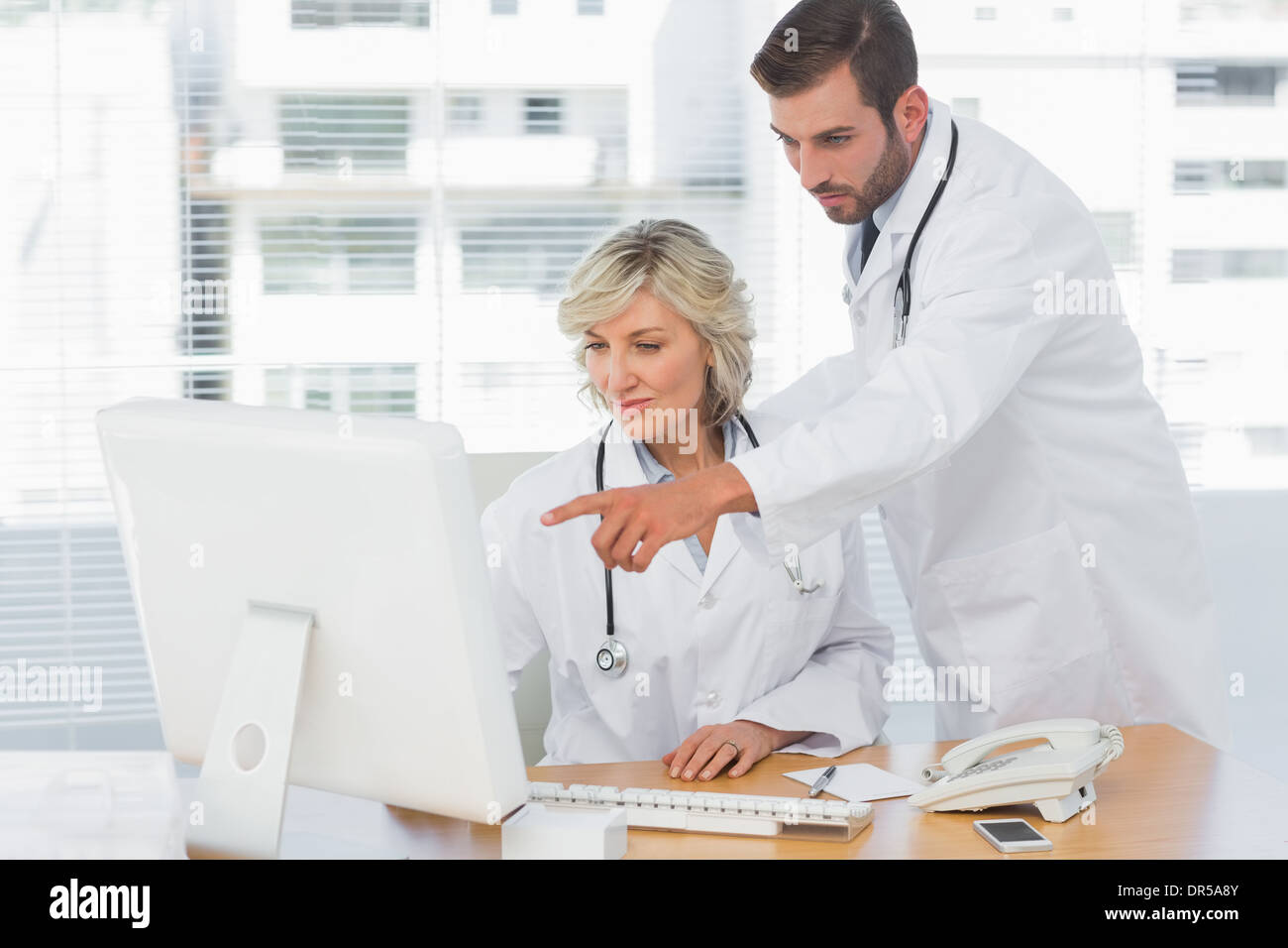 Doctors using computer at medical office Stock Photo - Alamy