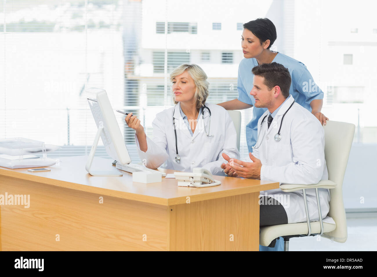 Doctors using computer together at medical office Stock Photo - Alamy