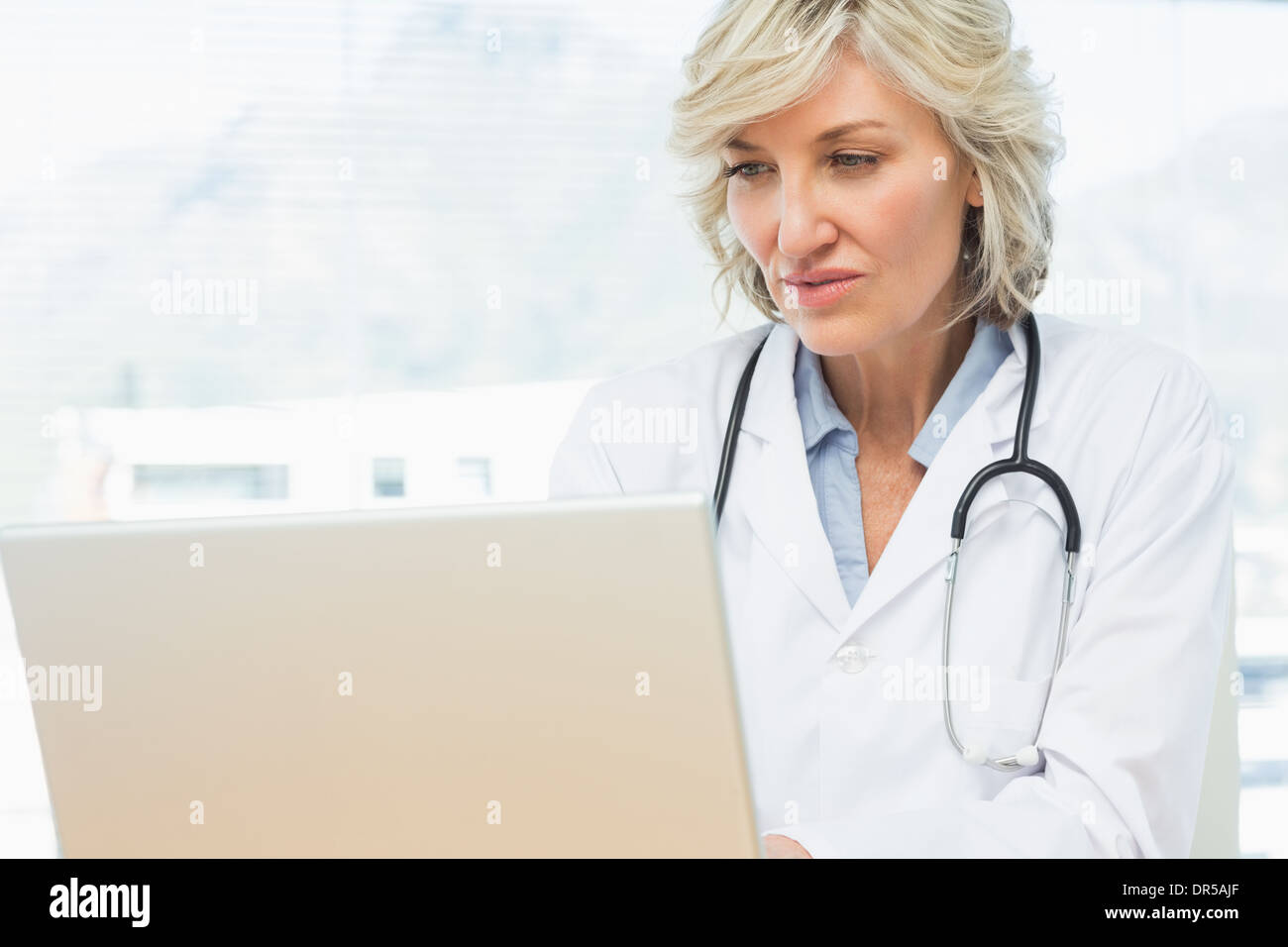 Female doctor using laptop in medical office Stock Photo - Alamy
