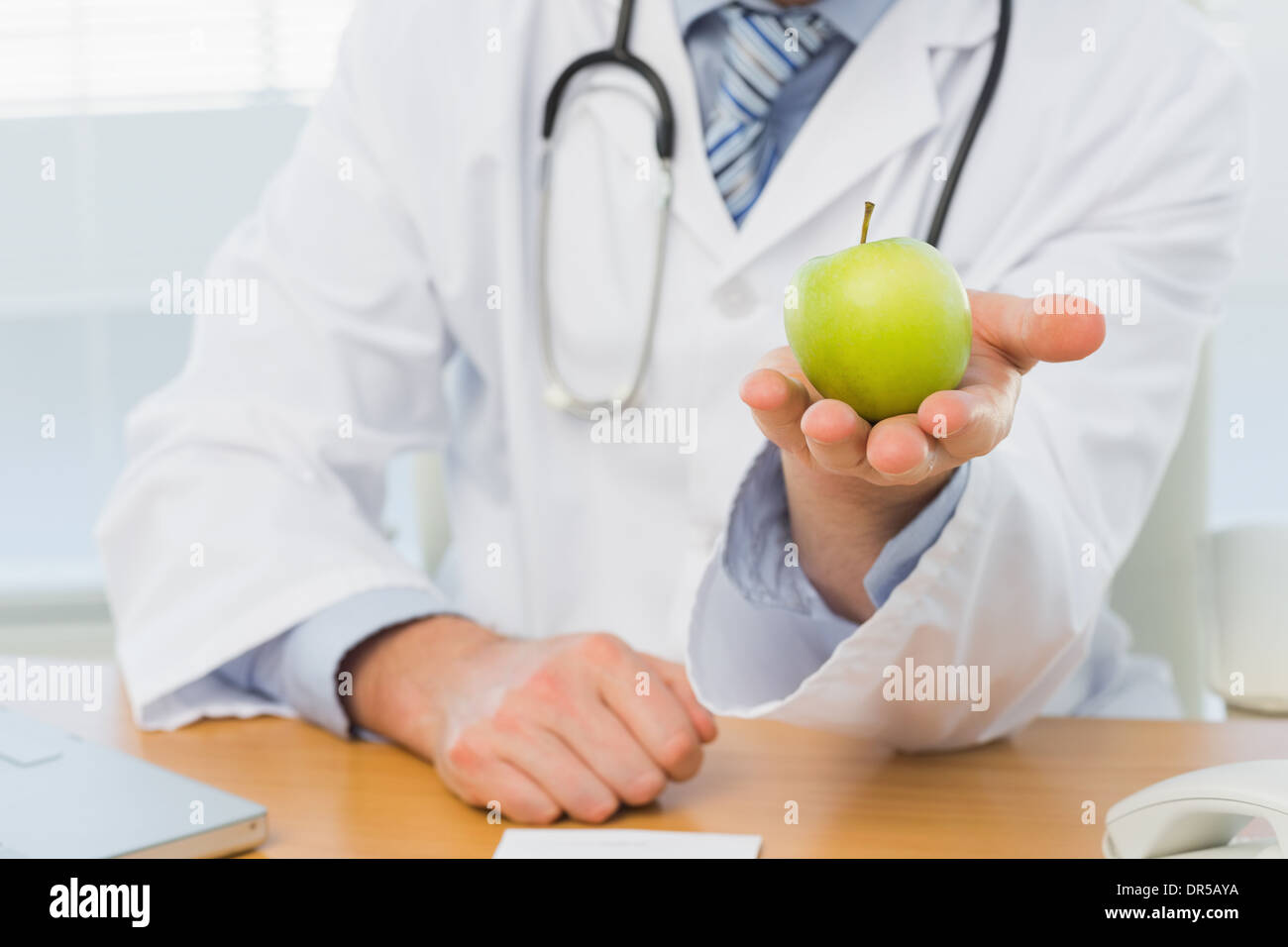 Mid section of a male doctor holding an apple Stock Photo - Alamy
