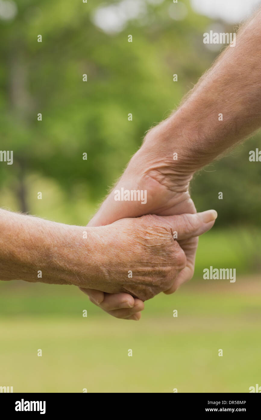 Elderly couple holding hands Stock Photo - Alamy