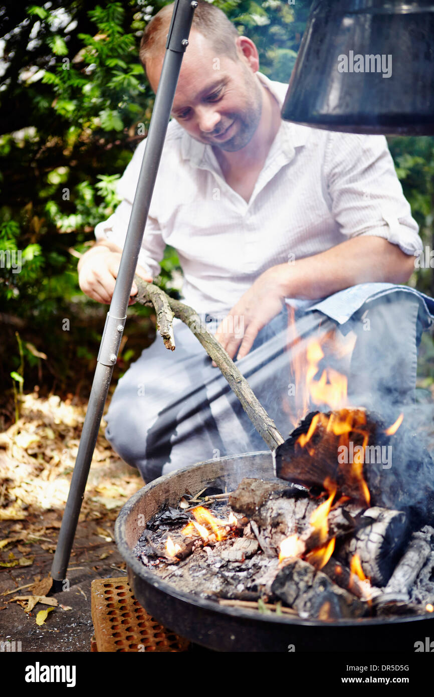 Man Tending To Bonfire Stock Photo - Alamy
