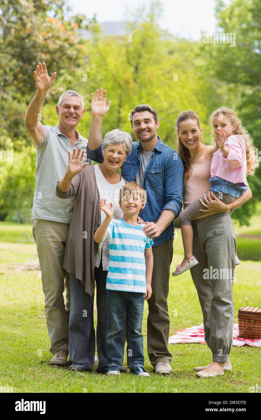 Extended family waving hands in park Stock Photo - Alamy