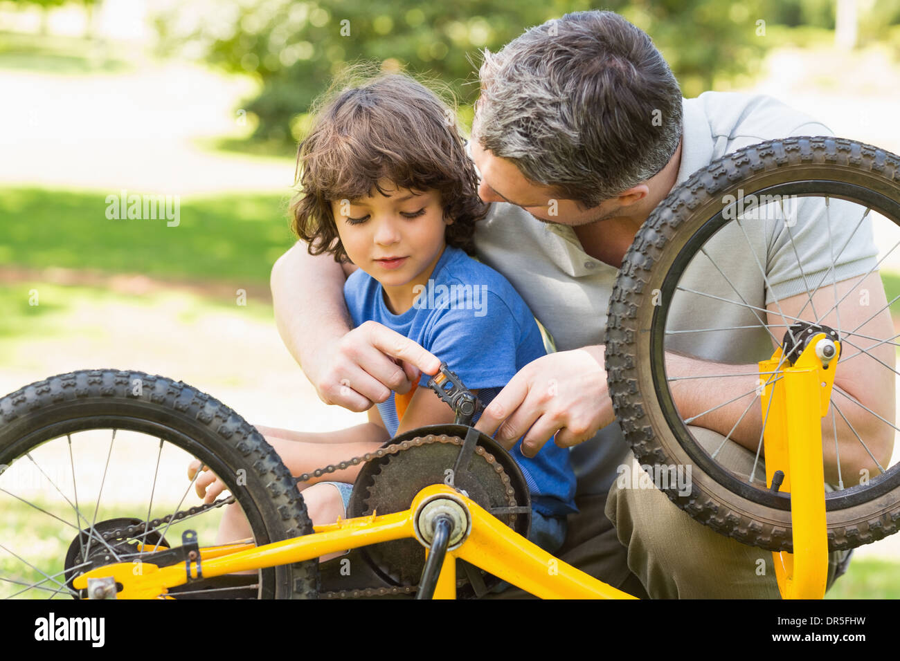 Father and son fixing bike Stock Photo - Alamy