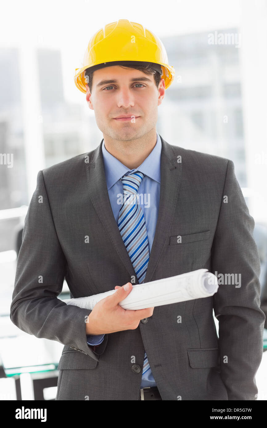 Happy architect holding blueprints looking at camera Stock Photo - Alamy