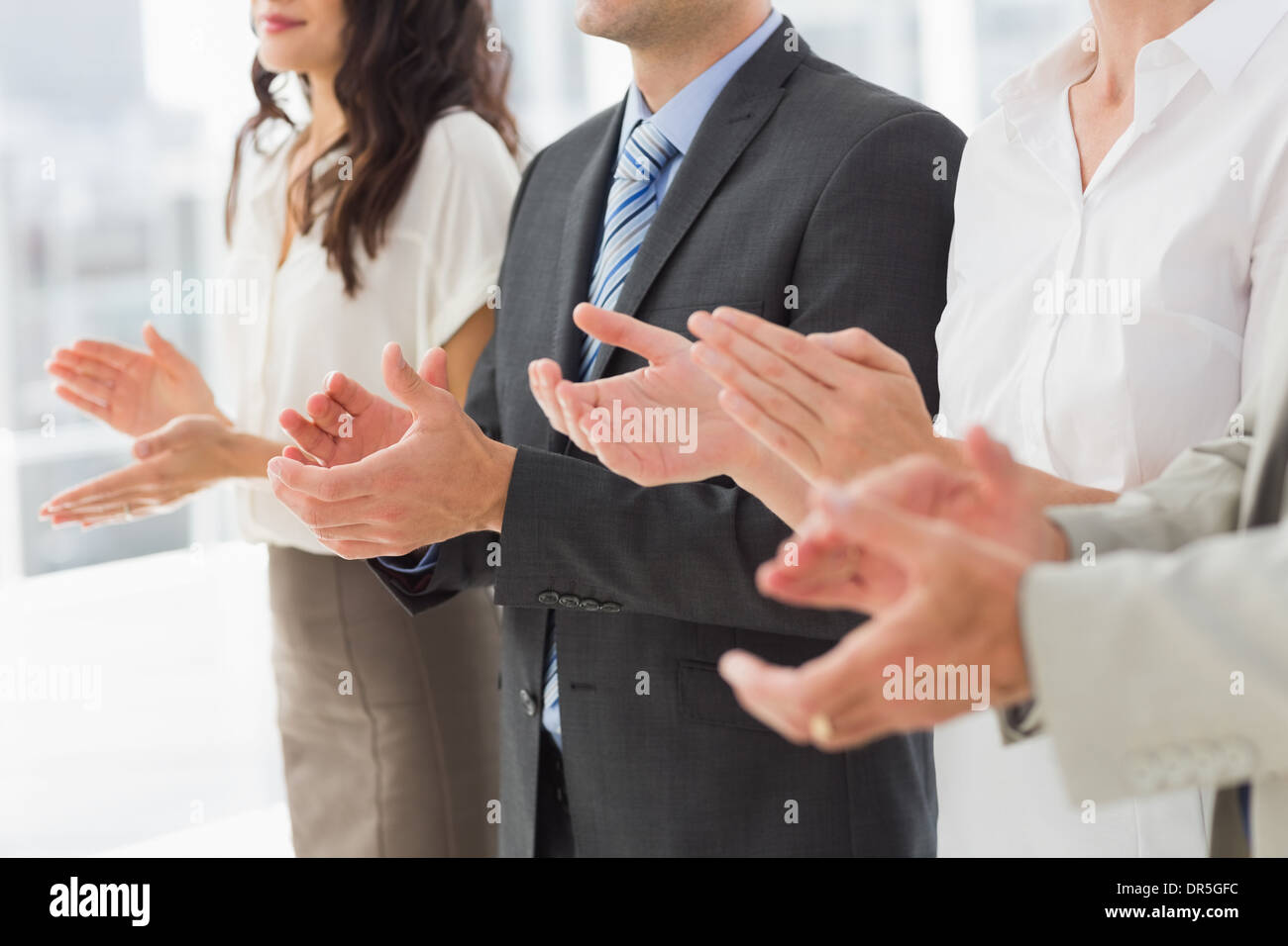 Business team standing in a row applauding Stock Photo - Alamy