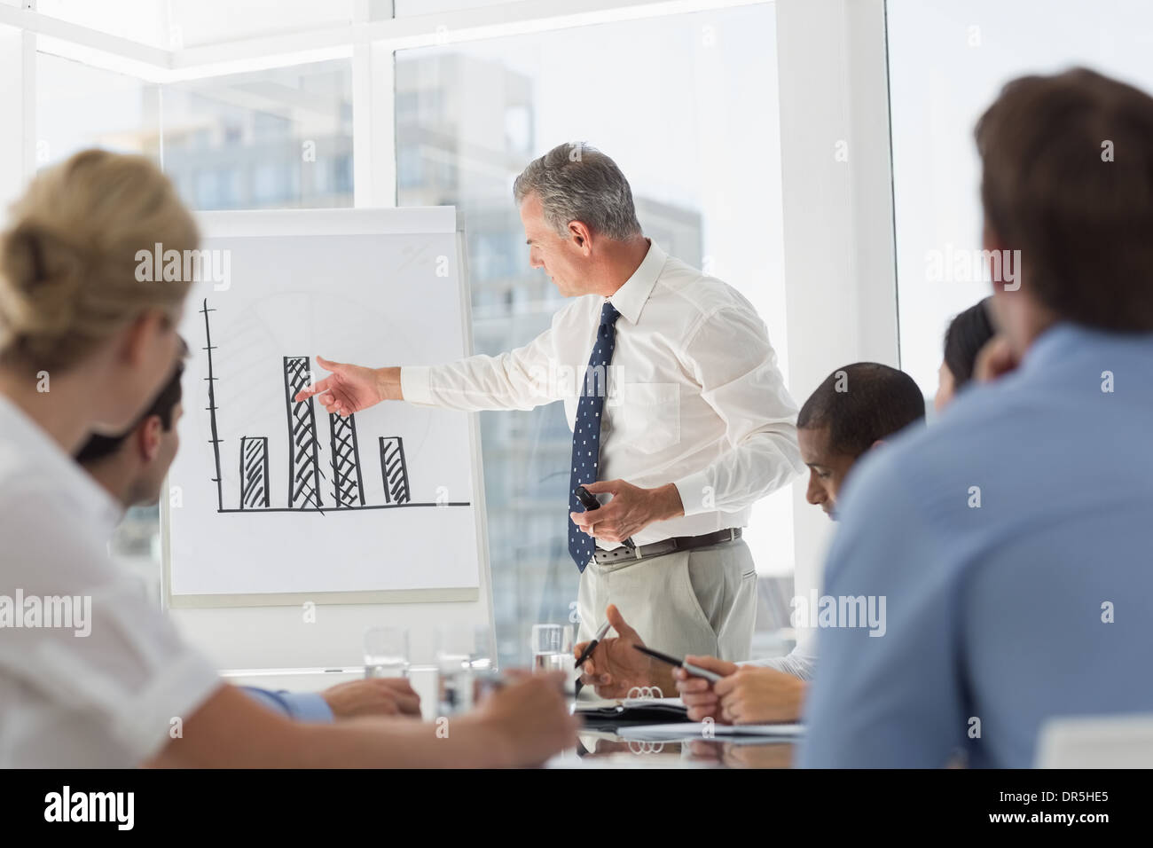 Senior businessman presenting bar chart to his colleagues Stock Photo ...