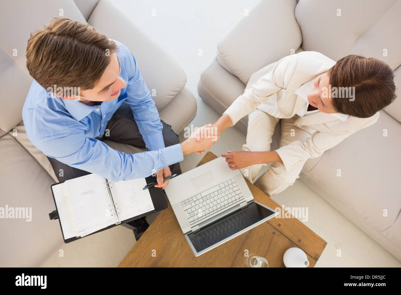 Business team working together on the couch shaking hands Stock Photo ...
