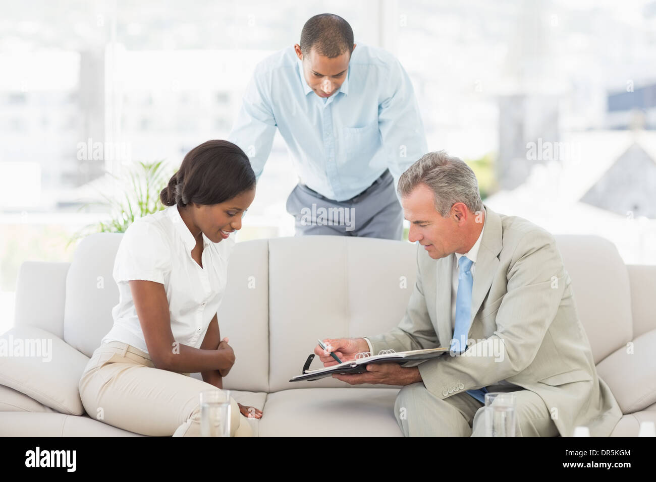 Salesman showing client where to sign the paperwork Stock Photo - Alamy