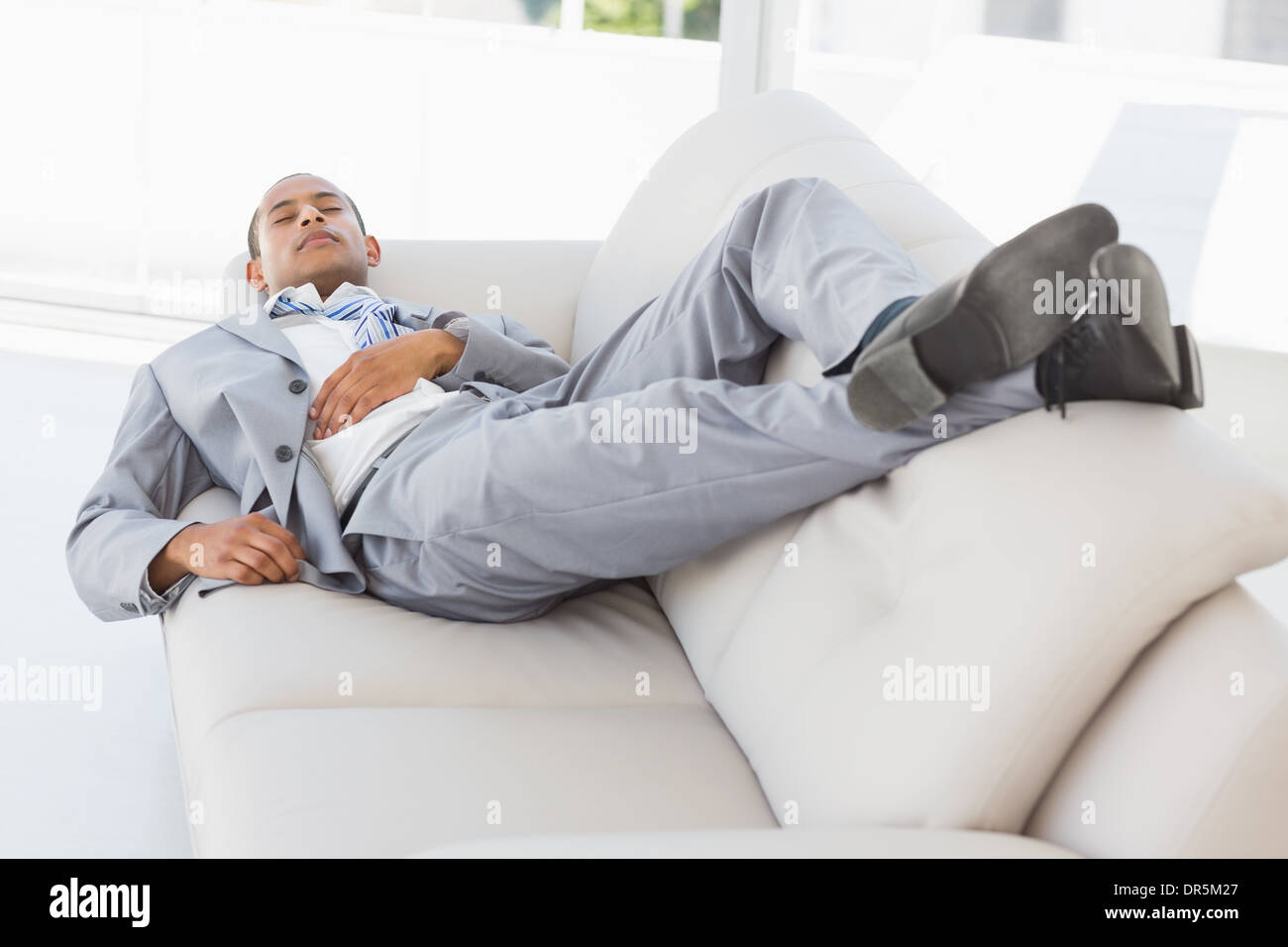Businessman napping on the couch Stock Photo - Alamy