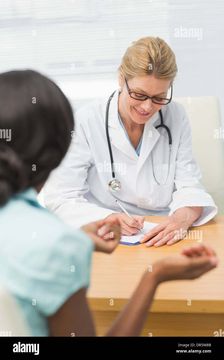 Doctor sitting desk taking notes hi-res stock photography and images ...
