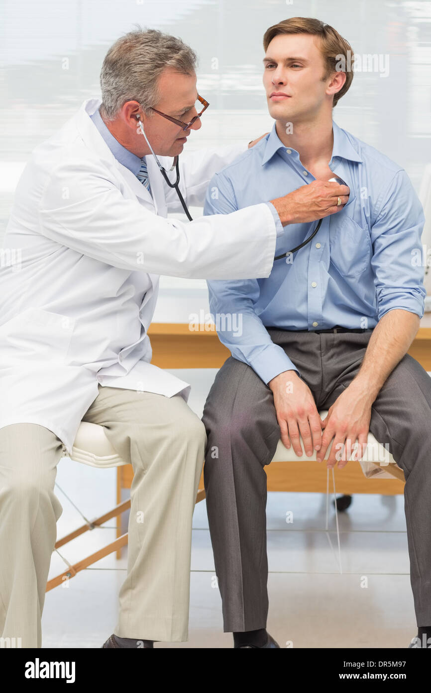 Doctor listening to his patients chest with stethoscope Stock Photo - Alamy