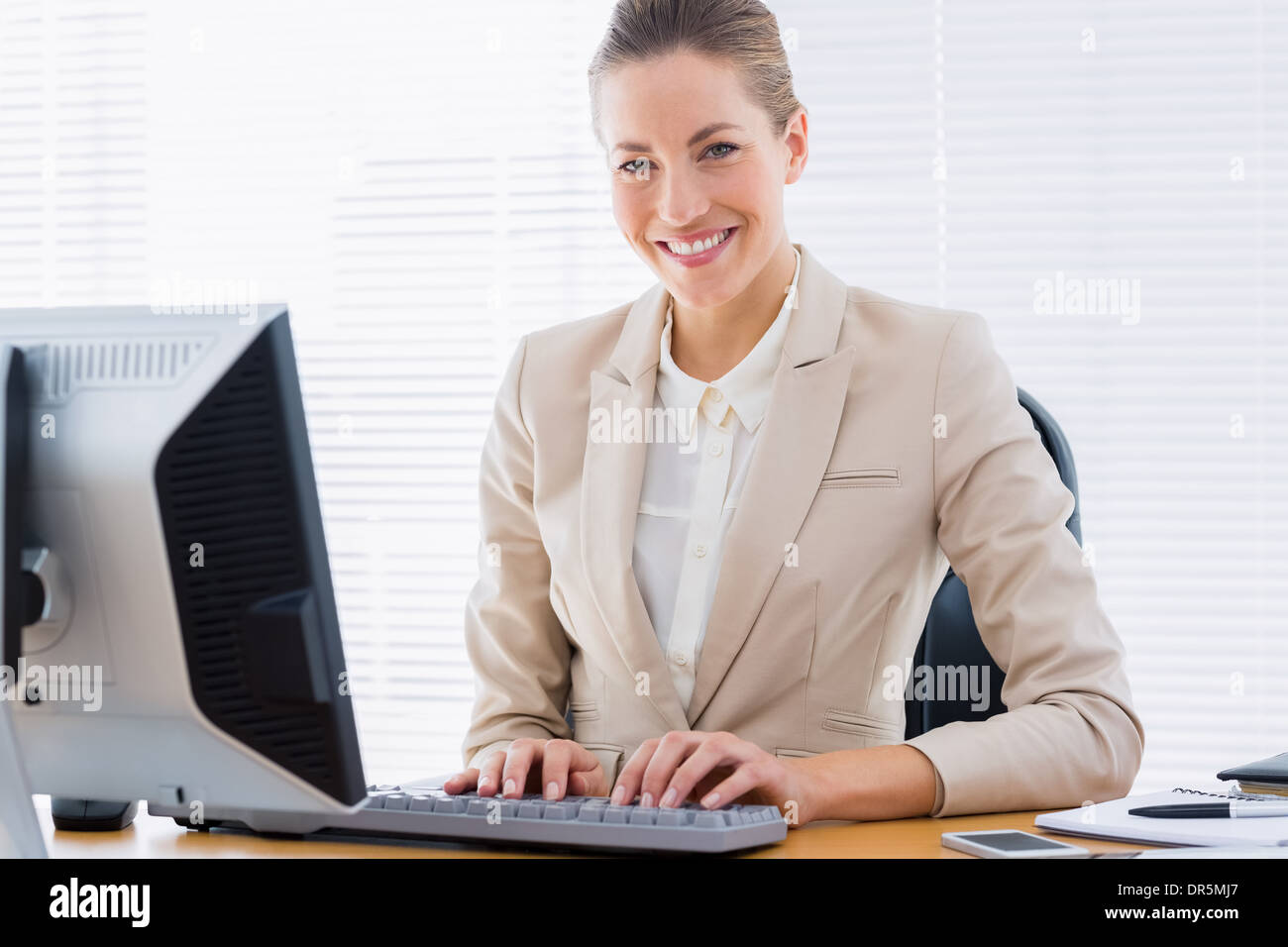 Businesswoman using computer at office desk Stock Photo - Alamy