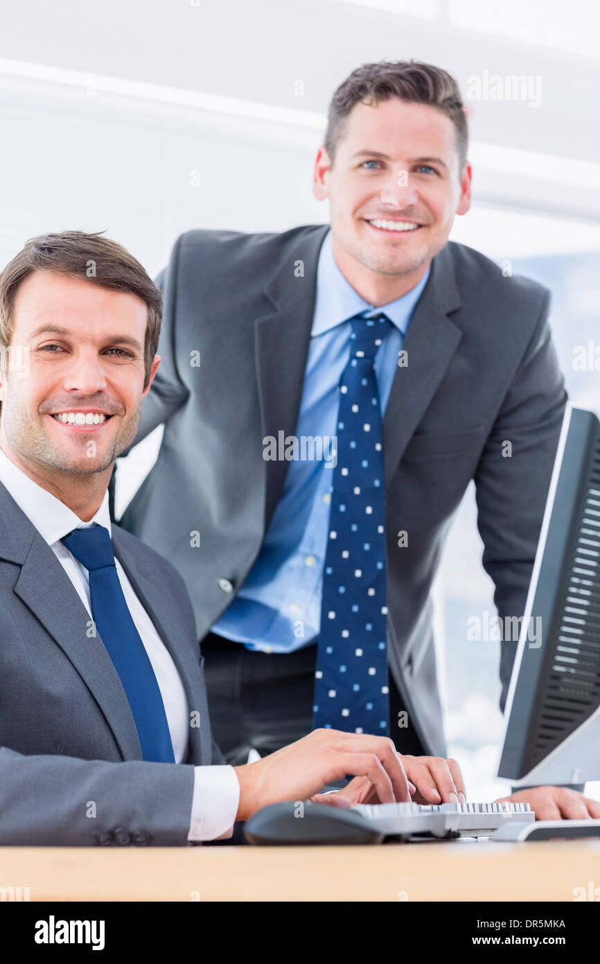 Businessmen using computer at office desk Stock Photo - Alamy