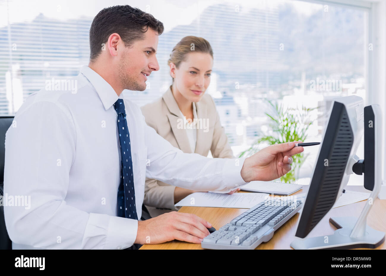 Smartly dressed colleagues using computer Stock Photo - Alamy