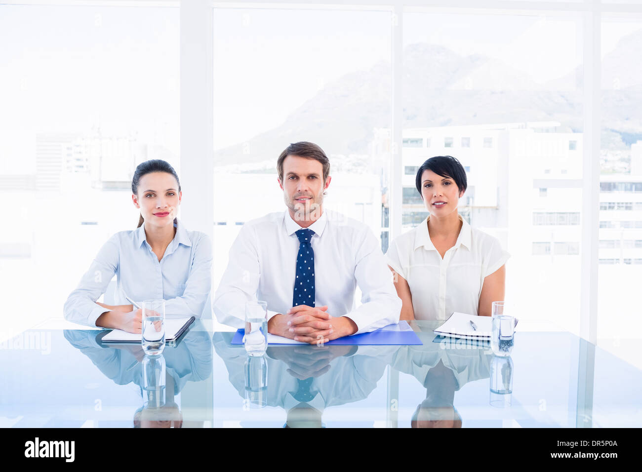 Smartly dressed young executives sitting at desk Stock Photo - Alamy
