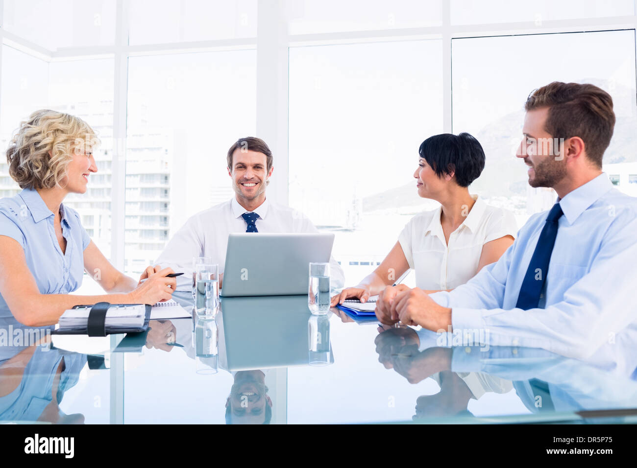 Executives sitting around conference table Stock Photo - Alamy