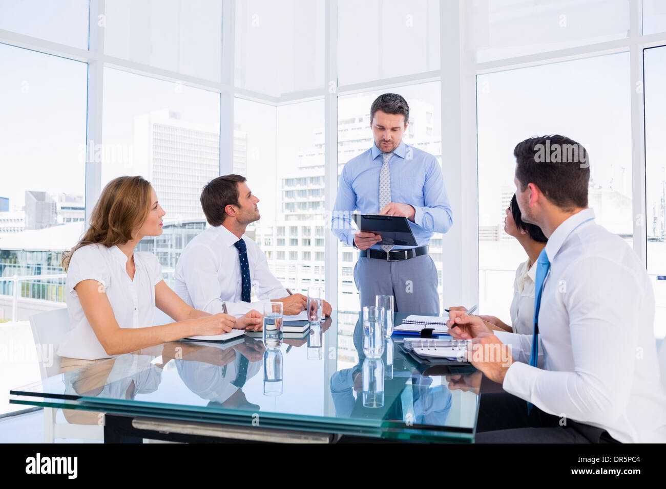 Executives sitting around conference table Stock Photo - Alamy
