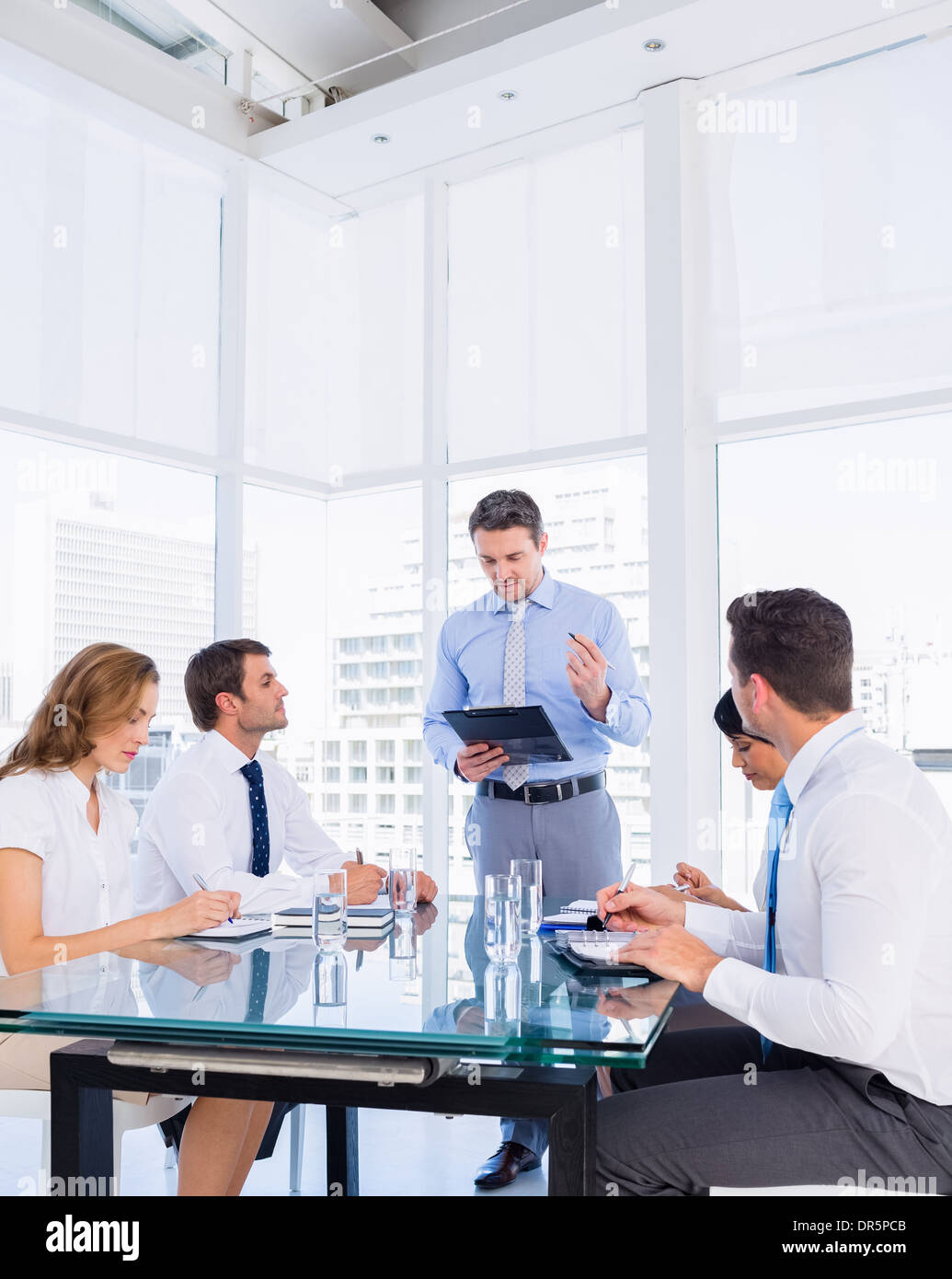 Executives sitting around conference table Stock Photo - Alamy