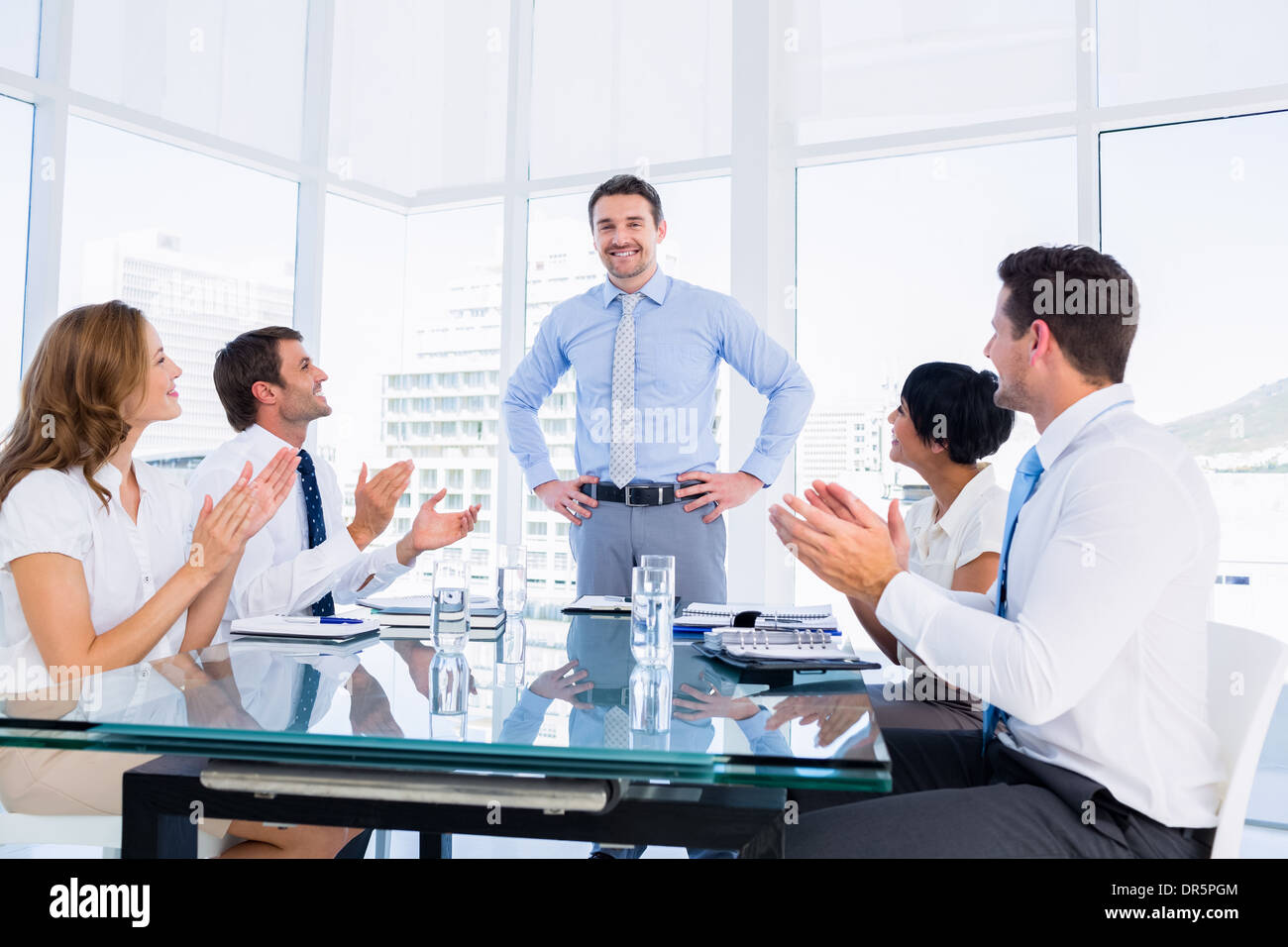 Executives clapping around conference table Stock Photo - Alamy