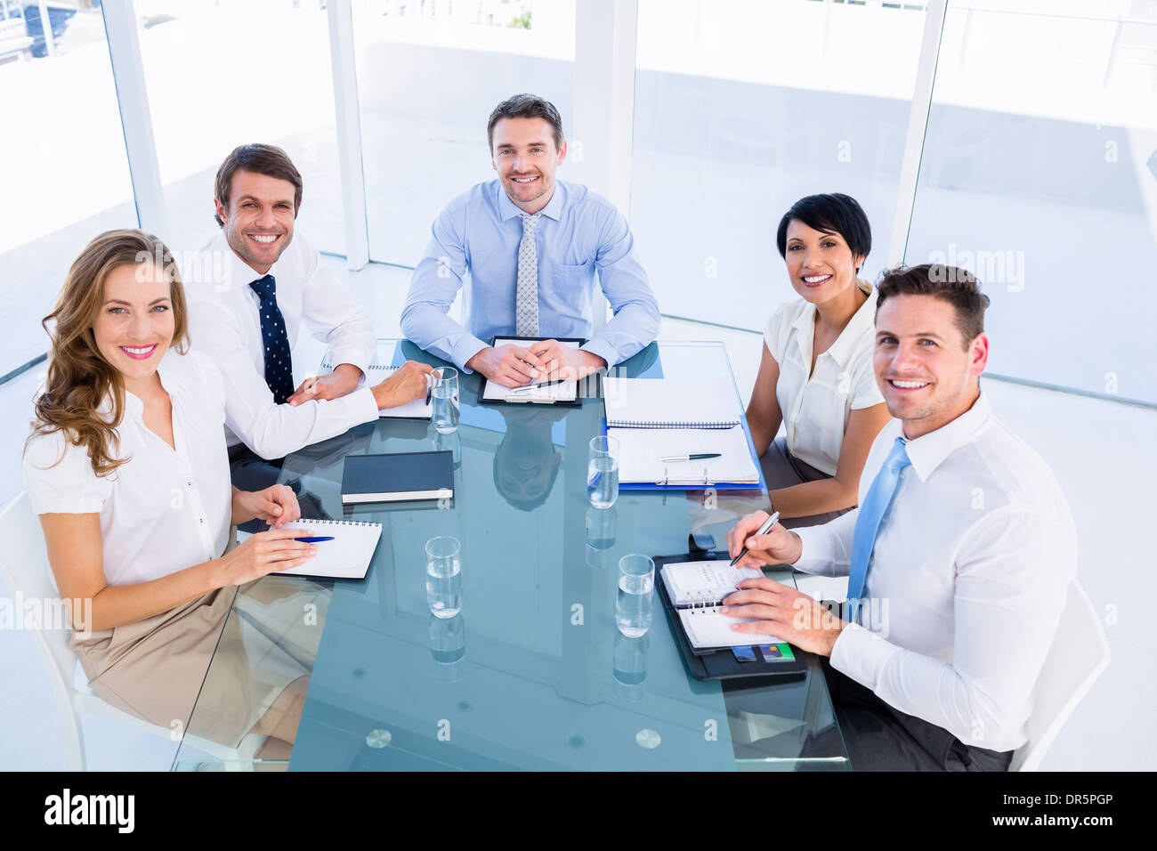 Executives sitting around conference table Stock Photo - Alamy