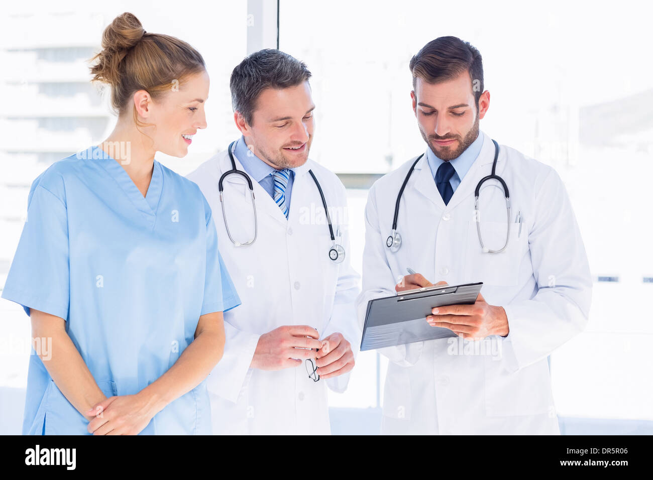 Doctors and female surgeon reading medical reports Stock Photo - Alamy
