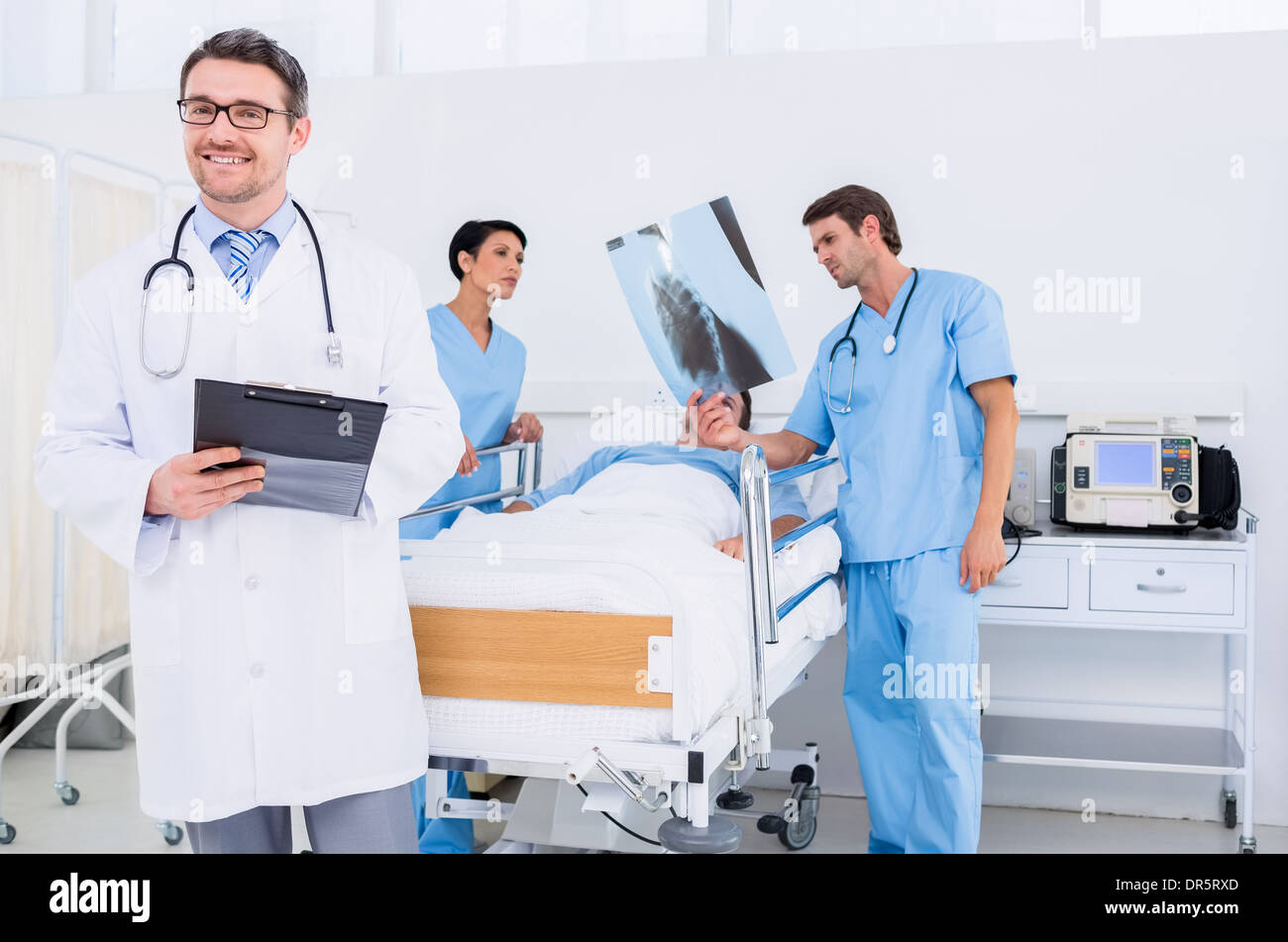 Doctors holding reports by patient at hospital Stock Photo - Alamy